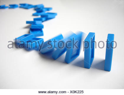 Dominos falling down in chain reaction Stock Photo - Alamy