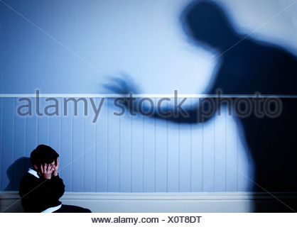 Shadow looming over frightened boy Stock Photo - Alamy