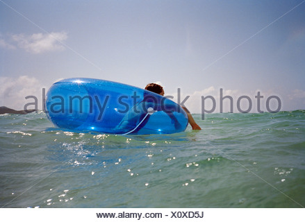 A woman floating on an inner tube in the sea Stock Photo: 13302763 - Alamy