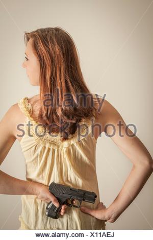 Back view of woman holding gun Stock Photo - Alamy