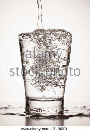 Pouring water into a glass, Overflowing Stock Photo: 28069032 - Alamy