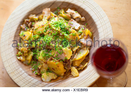 a plate of gröstl, a typical tyrolean food with meat, onions, chives ...