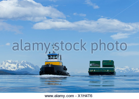 A tug pulling a barge cruises through the Inside Passage on its way ...