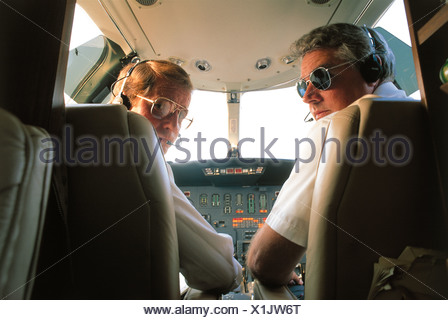 Two pilots in the cockpit, controlling the small aircraft Cessna 406 ...