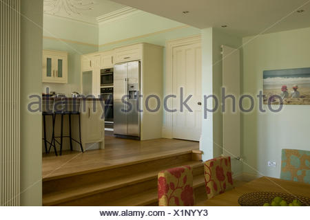 Modern split level dining room with steps up to kitchen area Stock ...