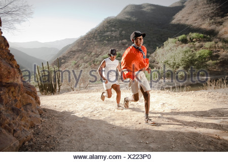 Two young Tarahumara runners running dressed with traditional clothes ...