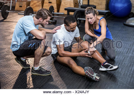 Young male bodybuilder standing knee bend, one leg squat, showing front ...