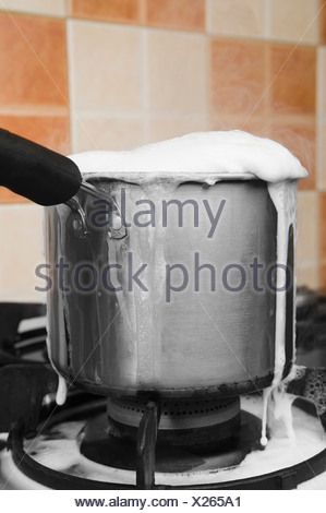 Milk boiling over a pan Stock Photo - Alamy