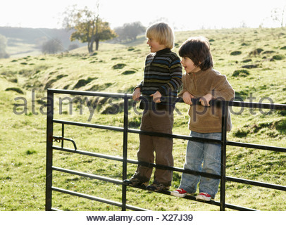 Children swinging on gate in countryside Stock Photo - Alamy