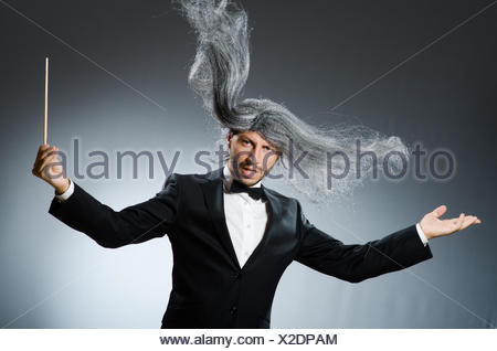 Funny conductor with long grey hair Stock Photo - Alamy