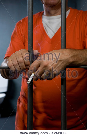 A prisoner smoking a cigarette in his prison cell Stock Photo: 20027689 ...