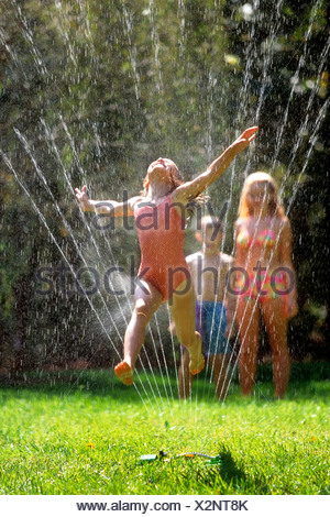 Girls running through sprinklers Stock Photo: 20245550 - Alamy