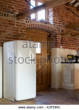 Large white Smeg refrigerator in barn conversion kitchen with exposed ...