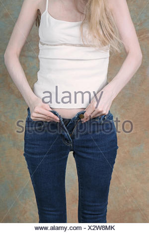 Woman zipping her blue jeans zip Stock Photo - Alamy