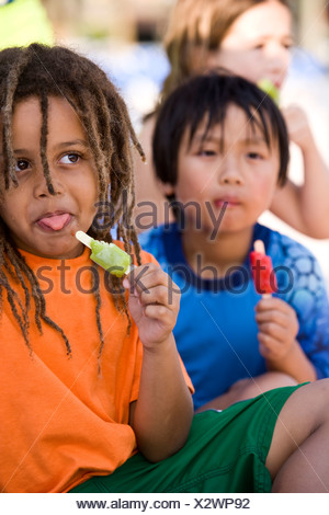 Multi-ethnic children eating popsicles at water park Stock Photo - Alamy