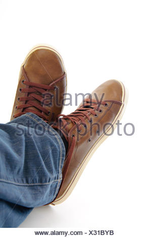 legs in brown shoes sneakers lying down isolated on white background ...