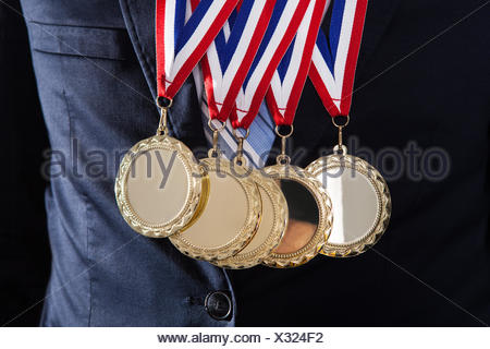Young man wearing gold medals standing in front of building Stock Photo ...