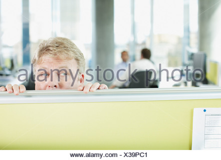 Businessman peeking over cubicle wall Stock Photo: 23883958 - Alamy
