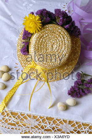 Close-up of straw hat decorated for Easter with purple and yellow dried ...