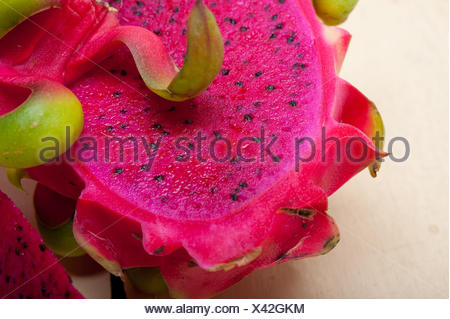 A fresh ripe dragon fruit with bright pink and green flesh skin on a ...