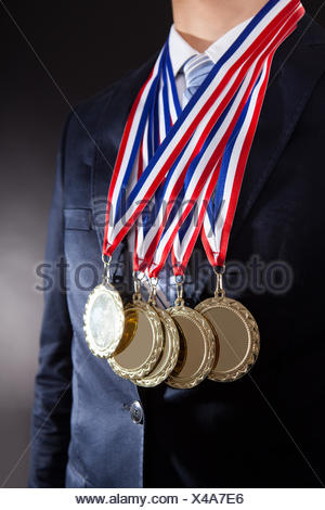 Young man wearing gold medals standing in front of building Stock Photo ...