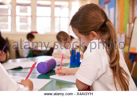 Pupils Working At Desks In Elementary School Classroom Stock Photo - Alamy