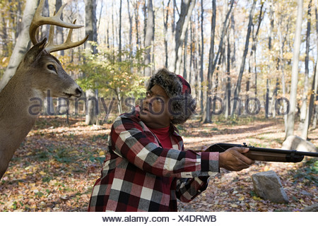 Deer standing behind a hunter Stock Photo: 21828384 - Alamy