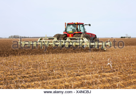 A Case IH tractor and field implement prepare a field in late Spring ...