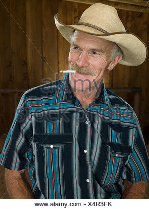 Cowboy with a cowboy hat smoking a cigarette Stock Photo: 19116981 - Alamy