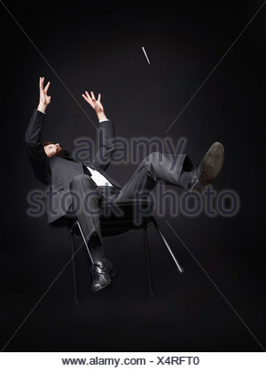 Man falling off a chair Stock Photo - Alamy