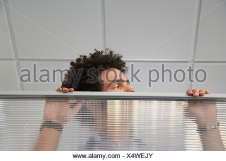 Office worker peering over cubicle wall Stock Photo: 72510779 - Alamy