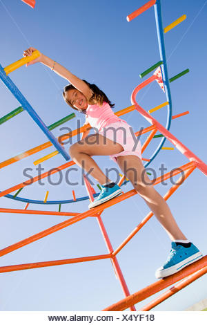 Girl climbing on monkey bars on playground Stock Photo: 72118715 - Alamy