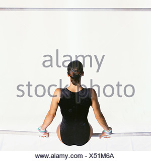 Female gymnast sitting on uneven bars, rear view Stock Photo: 5433143 ...