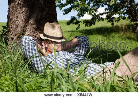 Man sleeping under a tree Stock Photo - Alamy