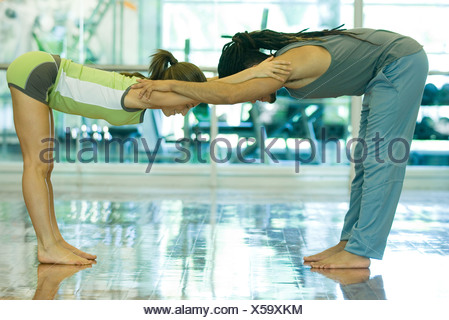 Woman bending over while a man is jogging in the background Stock Photo ...