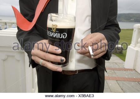 Man drinking a pint of Guinness stout beer on a Stag weekend in Stock ...