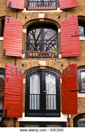 Red windows and red shutters on an old stone house the walled town of ...