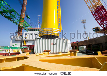 A crane lifts a transition piece of a wind turbine onto a jack up Stock ...