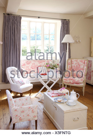 Pink Toile de Joule chair and small sofa in cottage living room with ...
