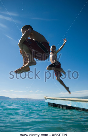 Boys Jumping off a dock Stock Photo - Alamy