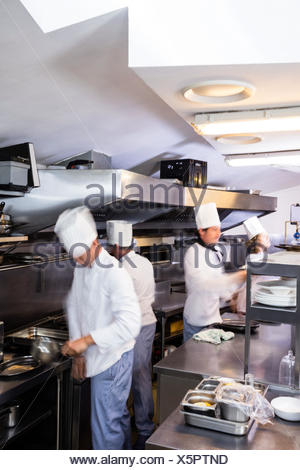 Team of restaurant kitchen staff busy at work Stock Photo - Alamy