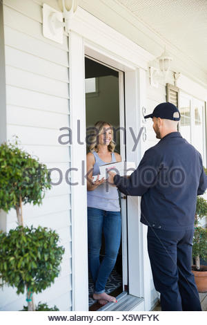 Woman receiving delivery at front door Stock Photo: 56531598 - Alamy