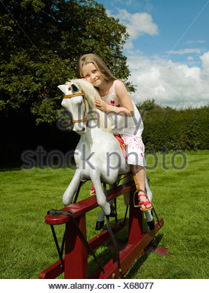 Girl smiling on rocking horse in playground Stock Photo: 72118720 - Alamy