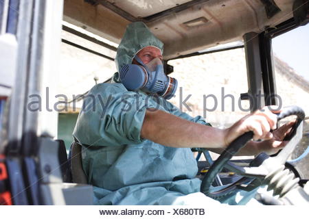 Farmer wearing protective suit and mask when applying chemicals on ...
