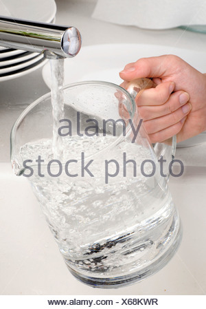 WOMAN FILLING JUG WITH TAP WATER Stock Photo - Alamy