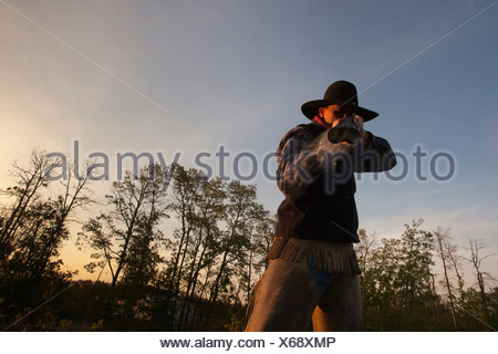 Cowboys shooting at the camera with their guns Stock Photo - Alamy
