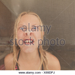Girl pressing nose against screen door Stock Photo: 28056483 - Alamy