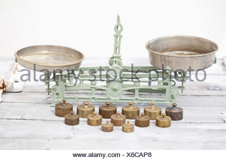 Old-fashioned weighing scale and weights against gray background Stock ...