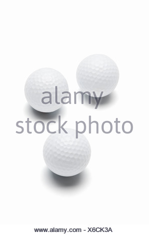 Three golf balls close up on a green red and blue tees. Cut out on a ...