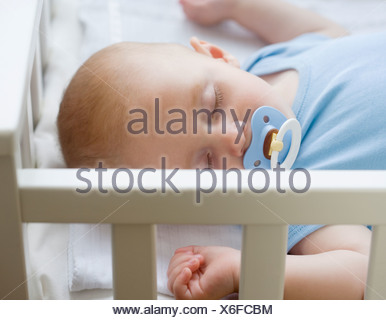 Baby girl with pacifier inside crib Stock Photo: 87249502 - Alamy